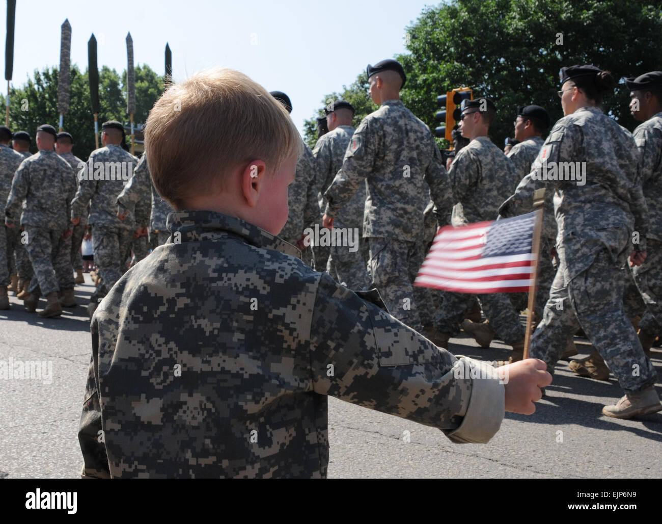 A small boy waves an American flag as 1st Infantry Division Soldiers ...
