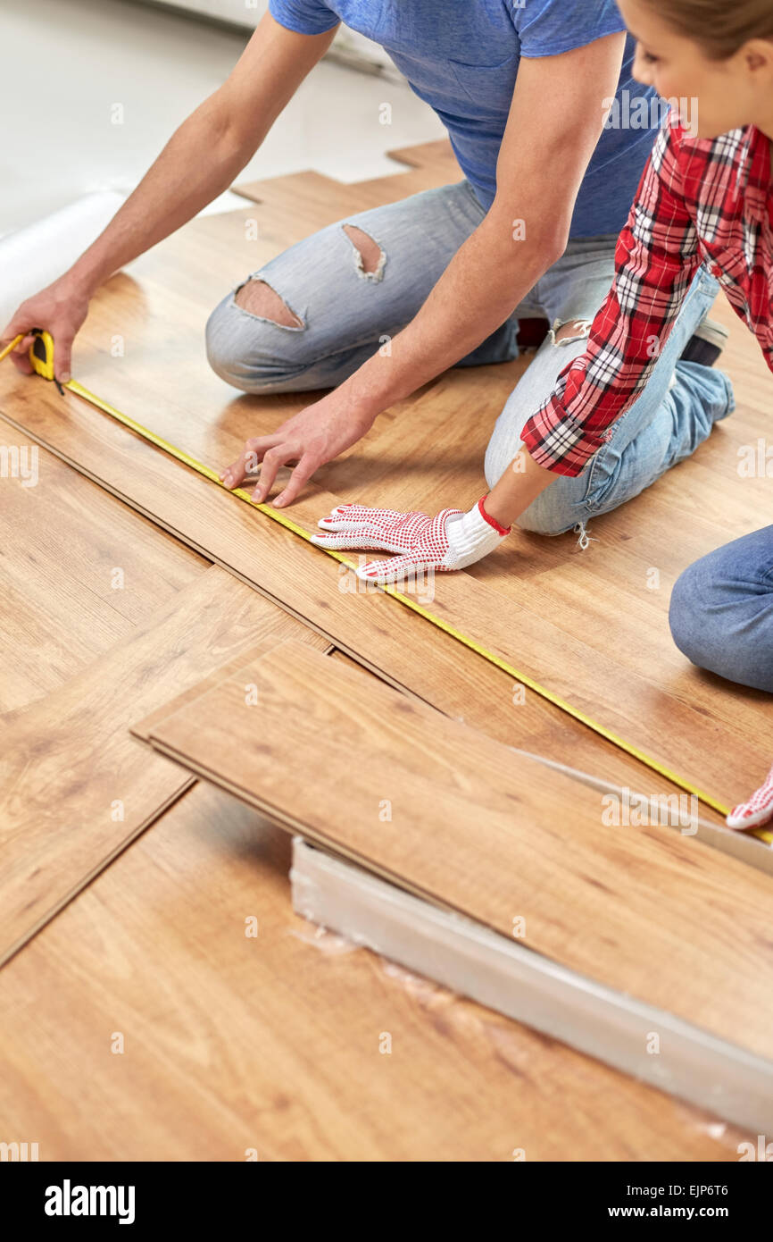 happy couple with ruler measuring parquet board Stock Photo - Alamy