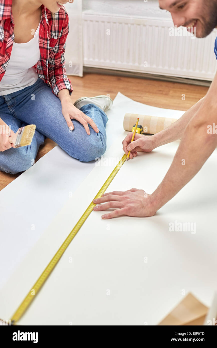 close up of happy couple measuring wallpaper Stock Photo - Alamy