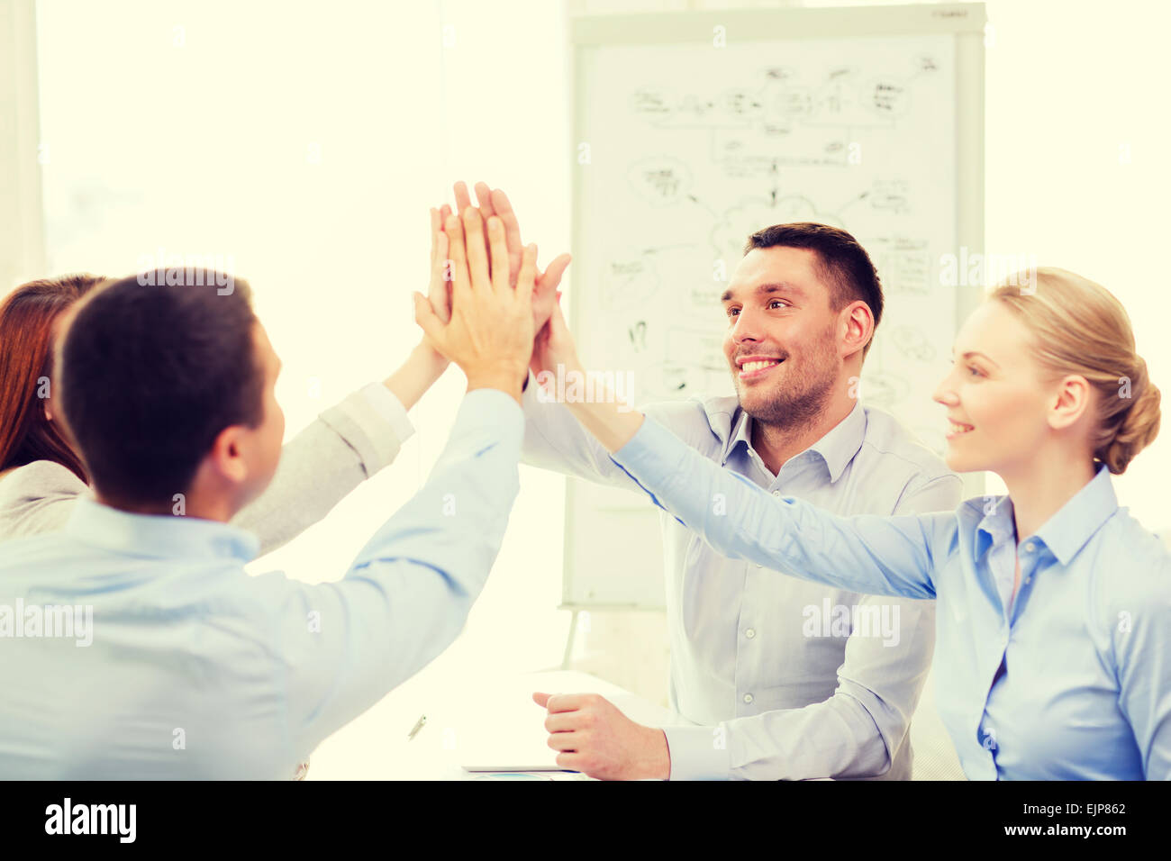 happy business team giving high five in office Stock Photo - Alamy