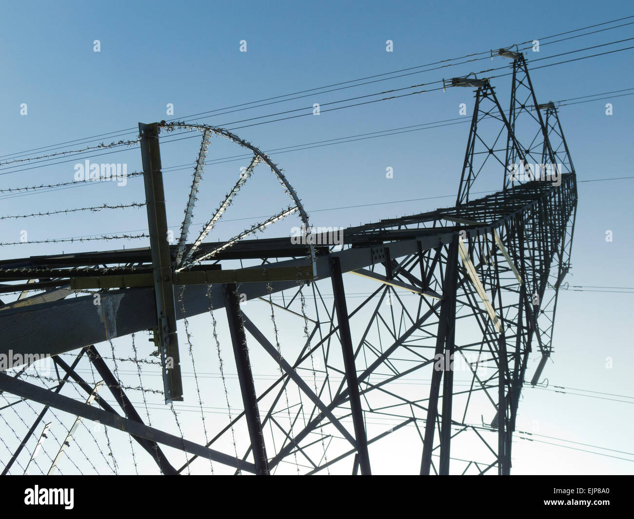 Barbed wire barrier around base of electricity pylon Stock Photo - Alamy