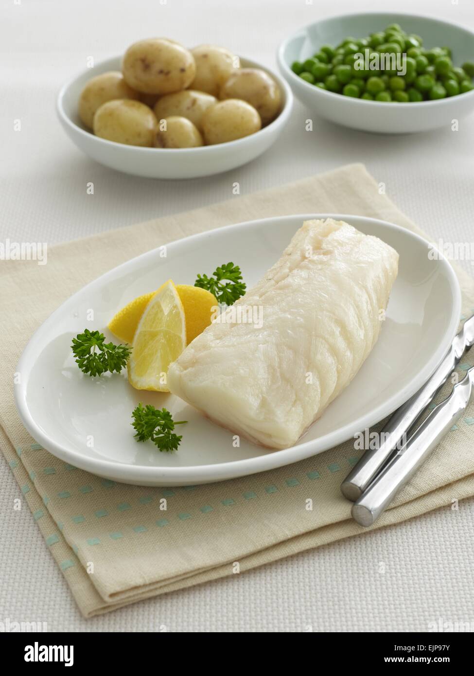 plated meal of pan fried plain fillet of haddock or cod fish with lemon ...