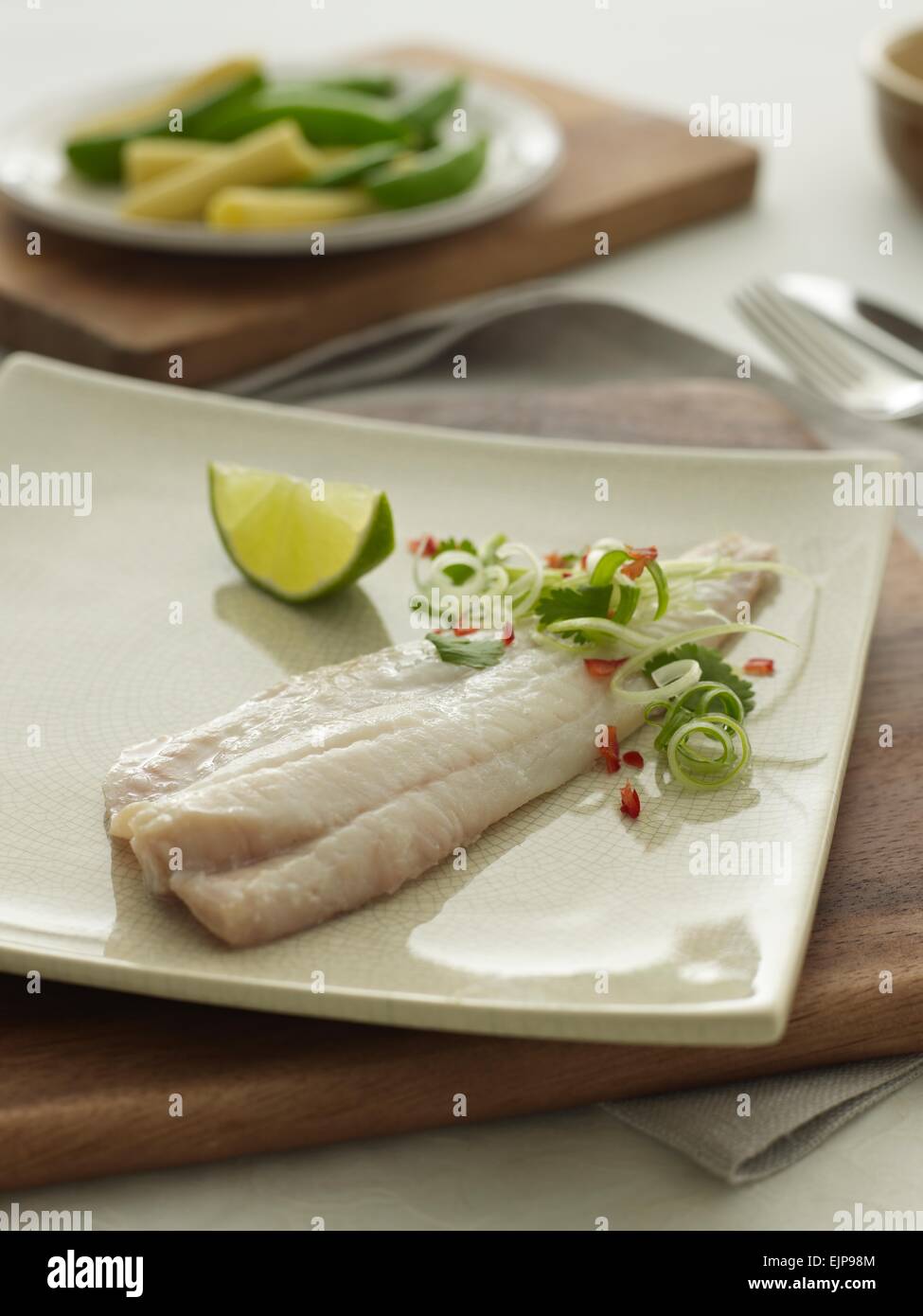 Plated meal of plain fillet of fish with lime parsley curls of spring ...