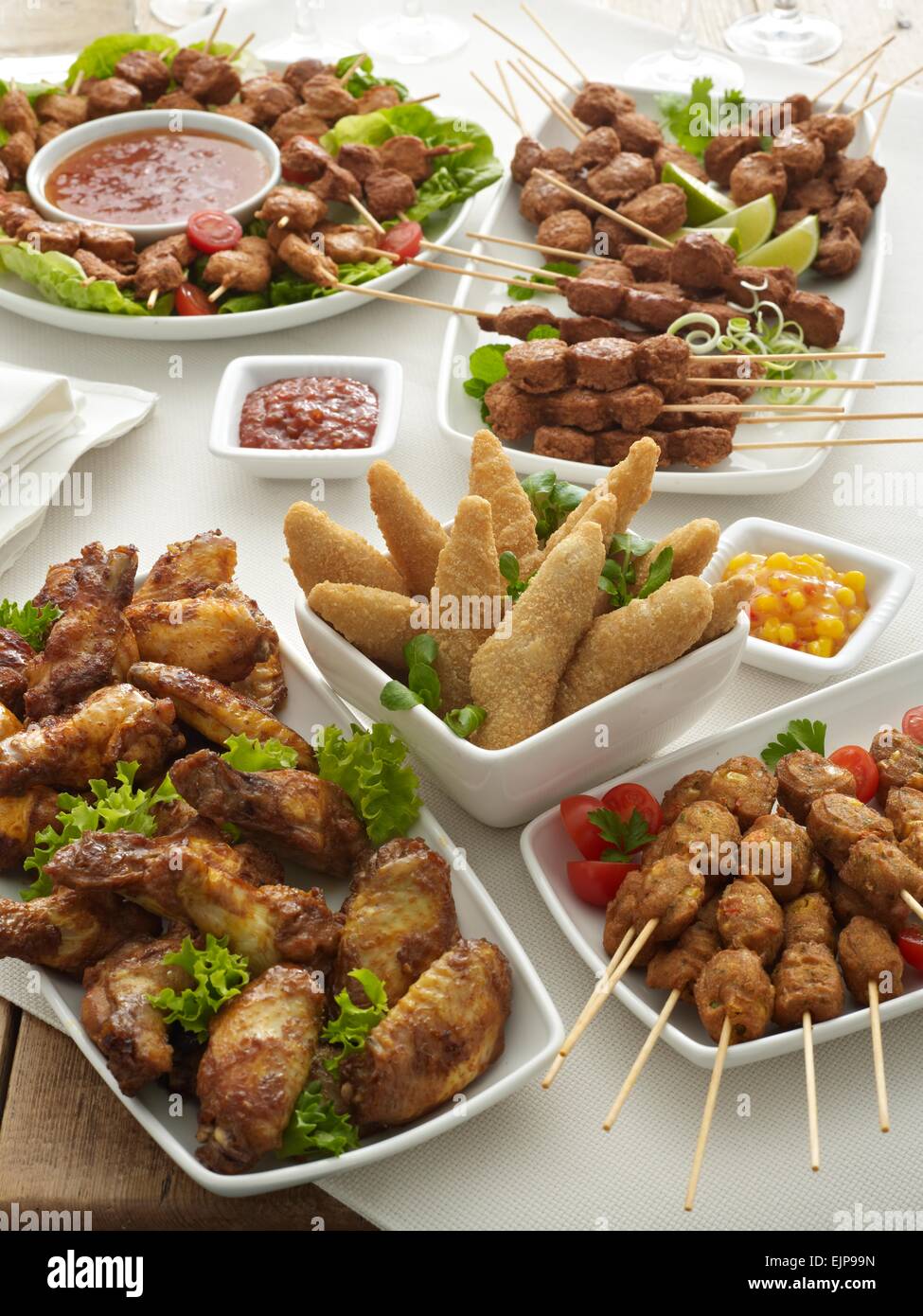 buffet table barbecued chicken pieces with skin lettuce and dips. legs ...