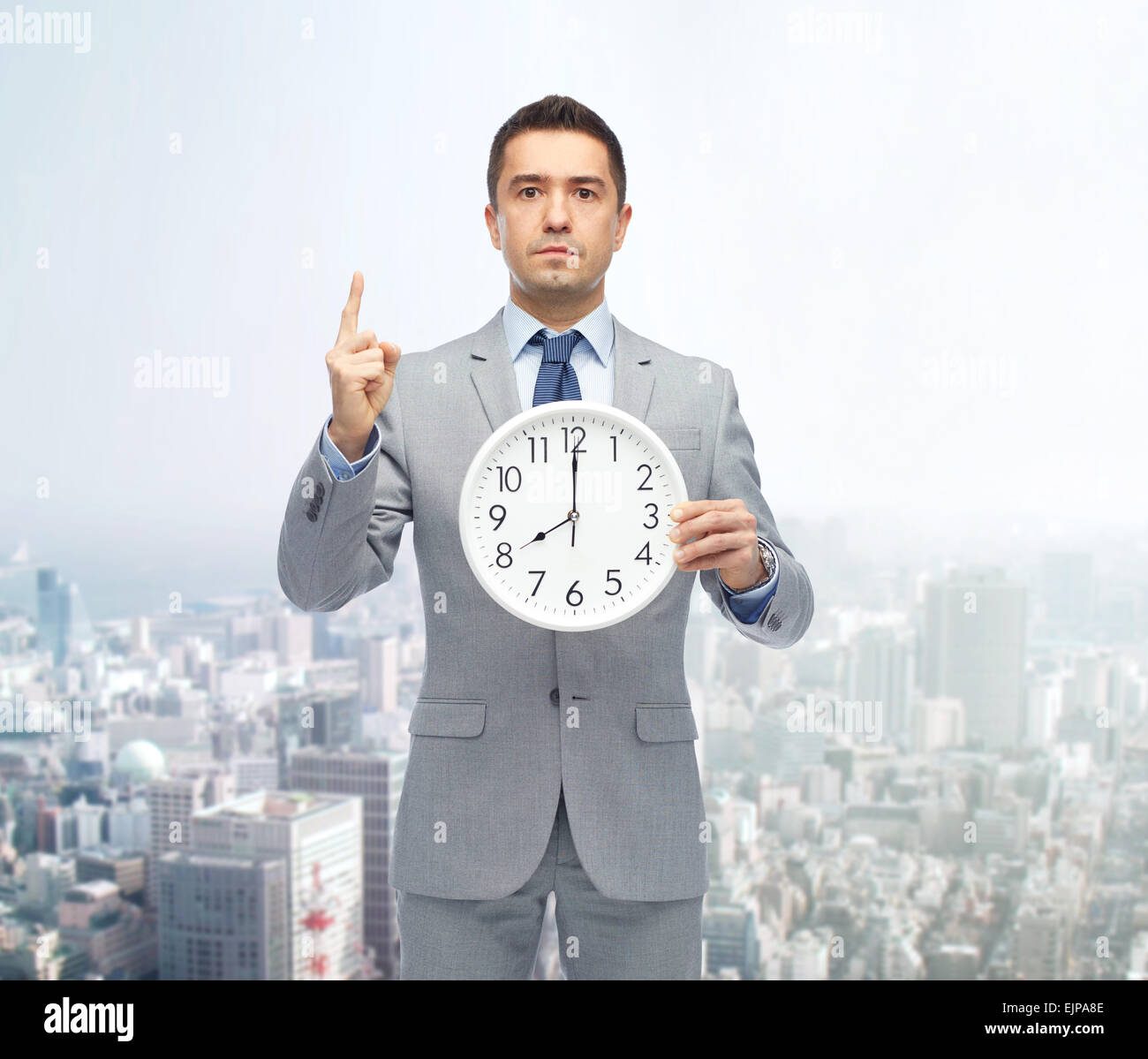businessman in suit holding clock with 8 o'clock Stock Photo - Alamy