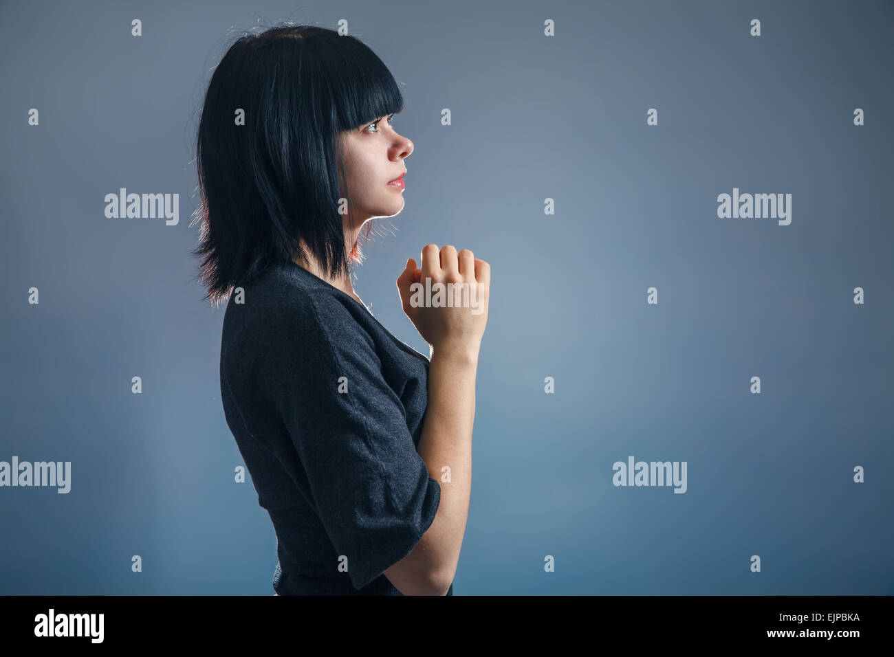 European-looking girl brunette in black jacket folded her hands Stock ...