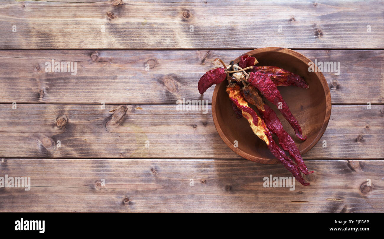 dry red peppers on a wooden table in a wooden bowl Stock Photo - Alamy
