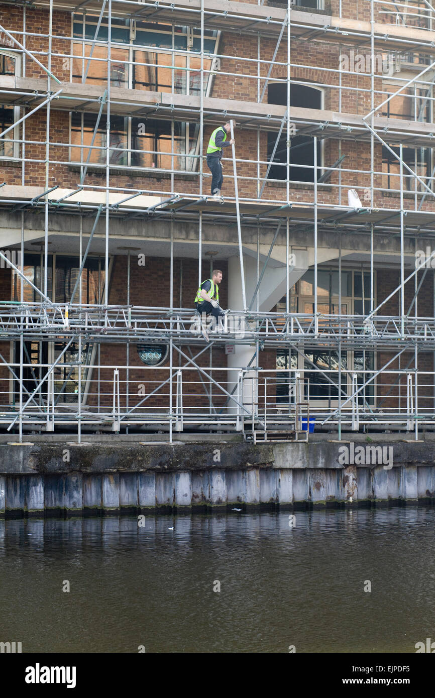 Men working on a building supported by Scaffolding Stock Photo - Alamy