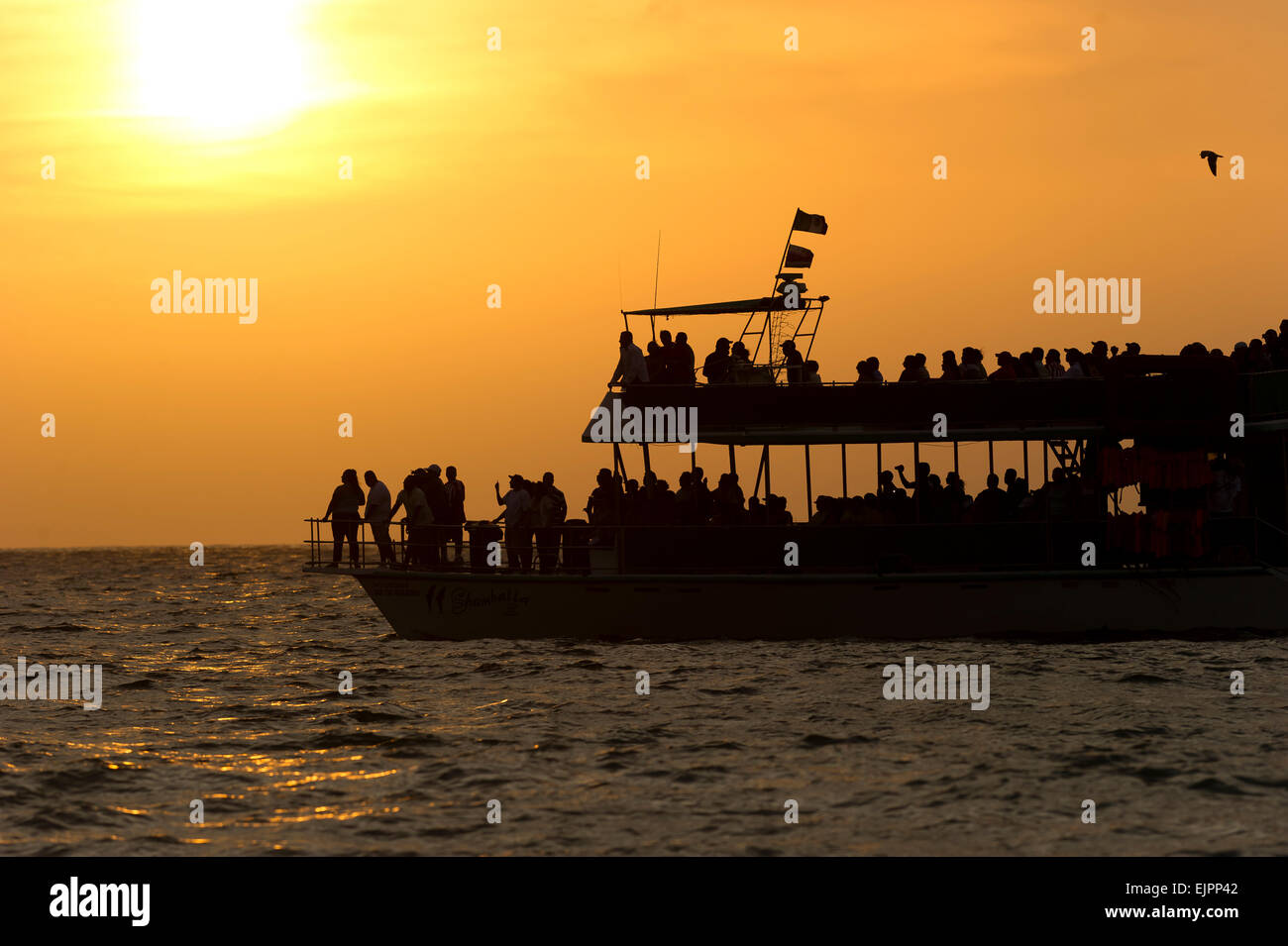 A tourist group of people is sailing along the ocean water with a ...