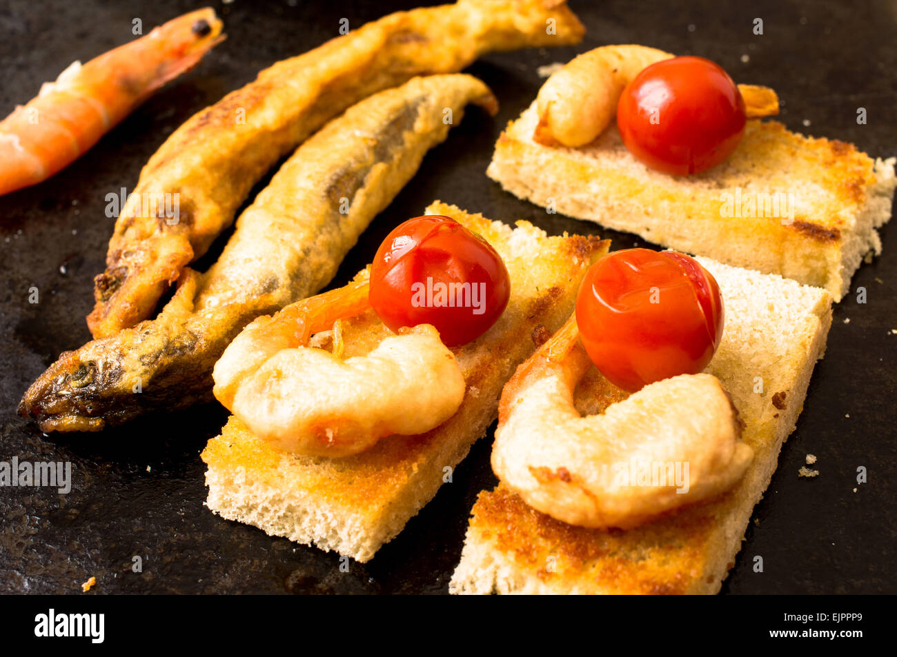 Tapas shrimp and fish tempura fries with cherry tomatoes Stock Photo ...
