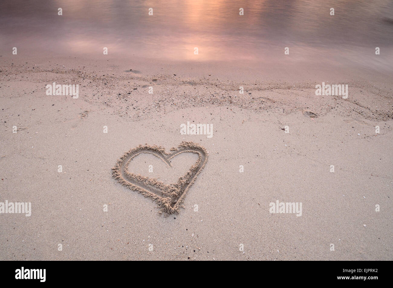 Heart or love shape handwritten on a beach Stock Photo - Alamy