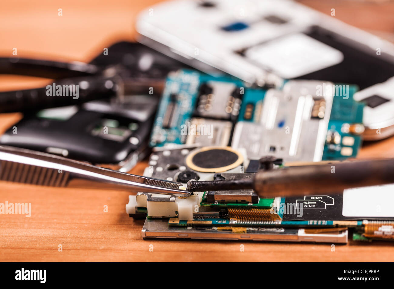 repair a broken mobile phone on wooden background Stock Photo - Alamy