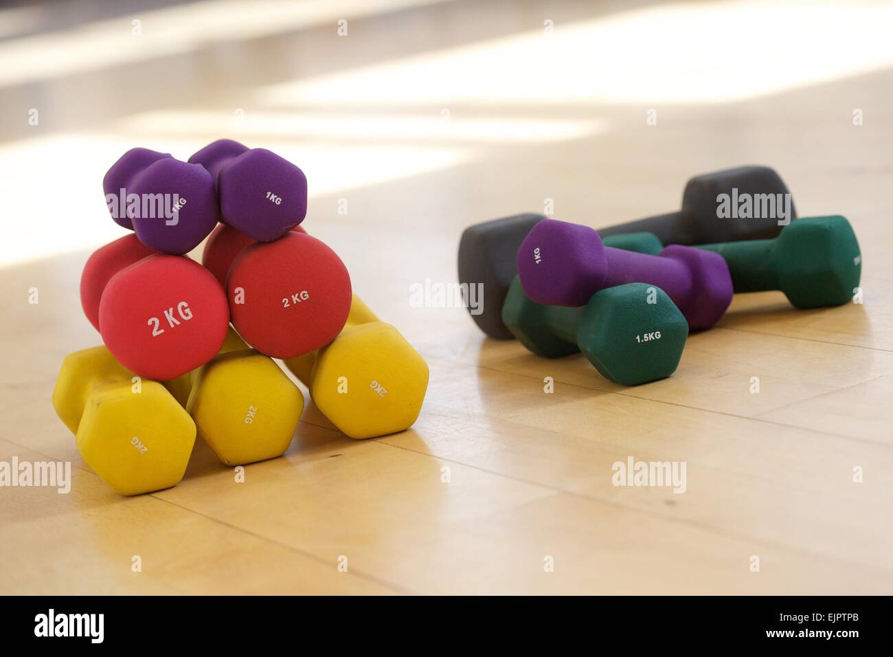 small dumbbell weights on gym floor Stock Photo - Alamy