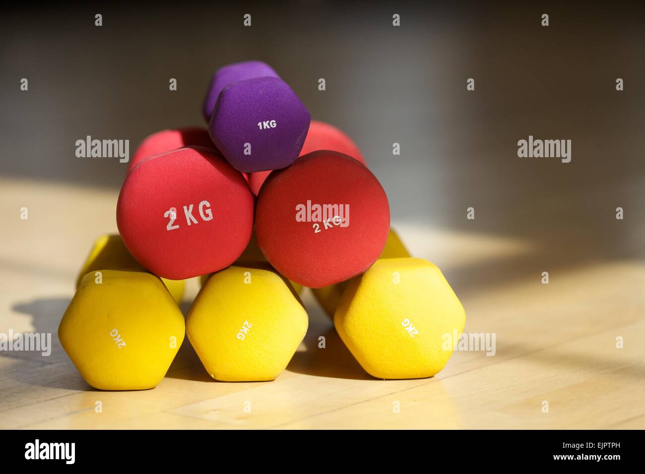 small dumbbell weights on gym floor Stock Photo - Alamy