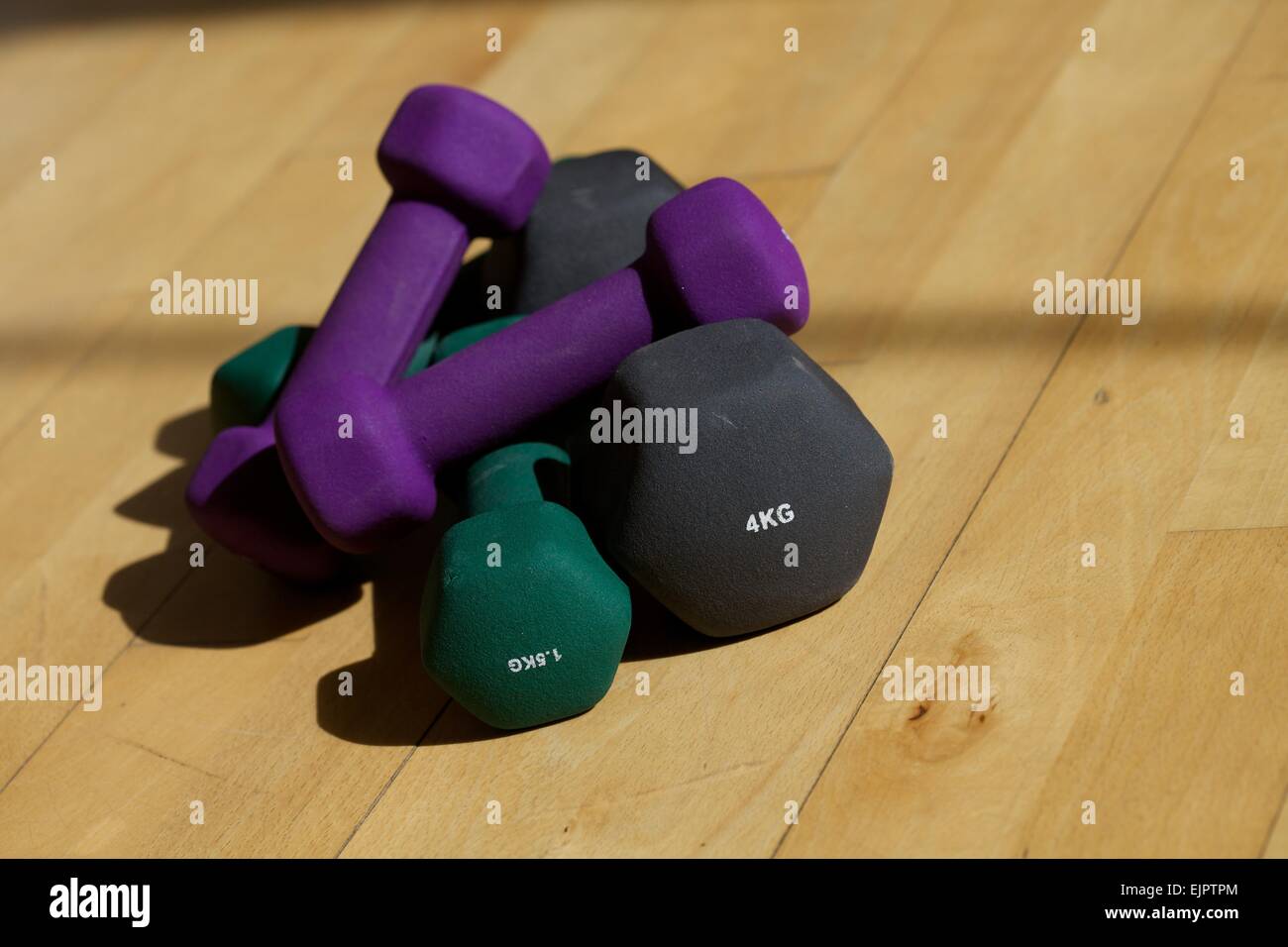 small dumbbell weights on gym floor Stock Photo - Alamy