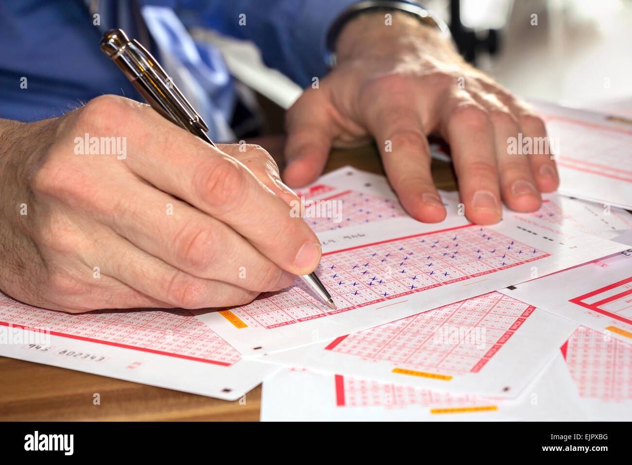 Man Marking on lottery ticket with a pen Stock Photo - Alamy