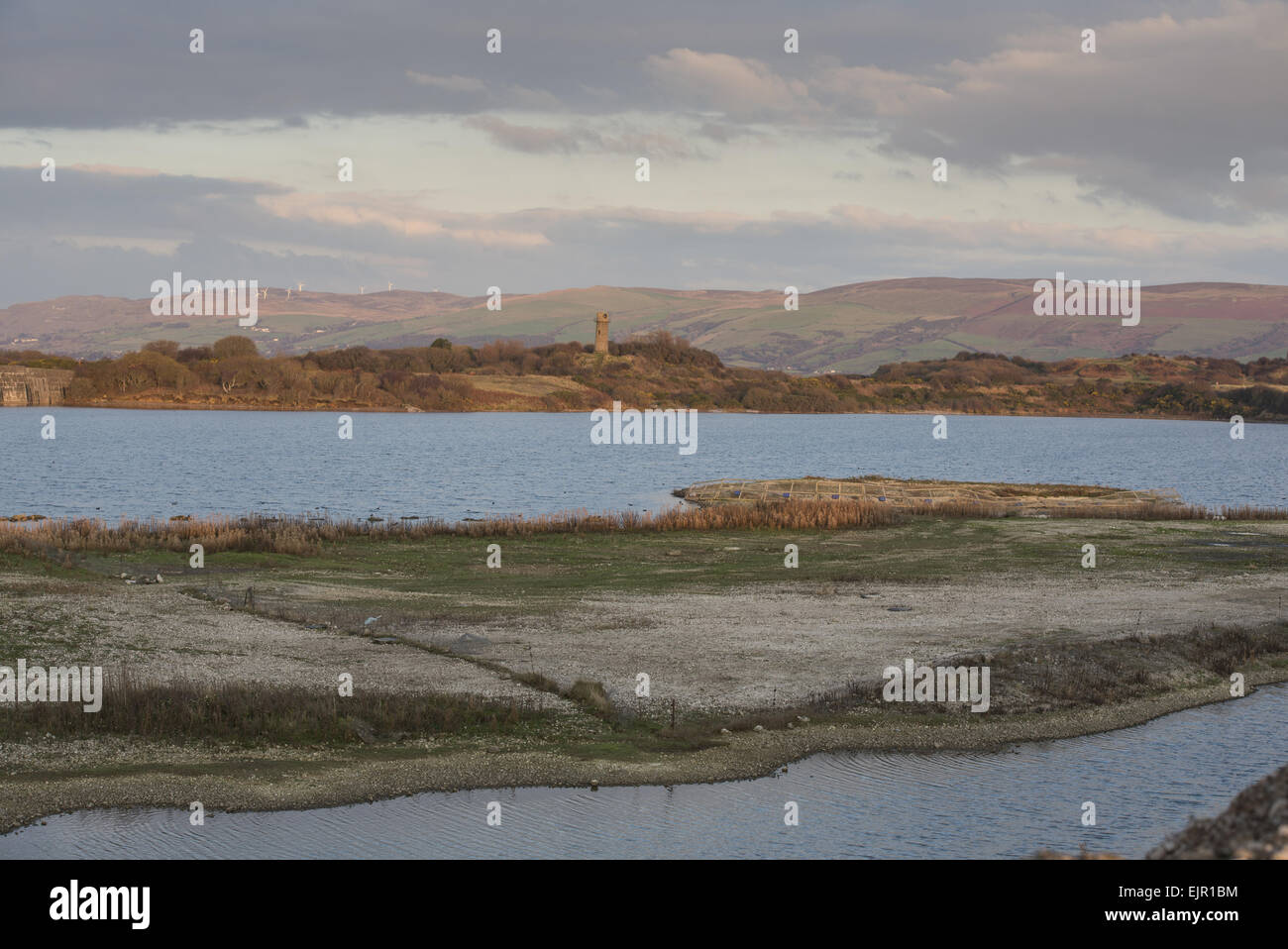 View of flooded former iron ore mining area, surrounded by sea wall on ...