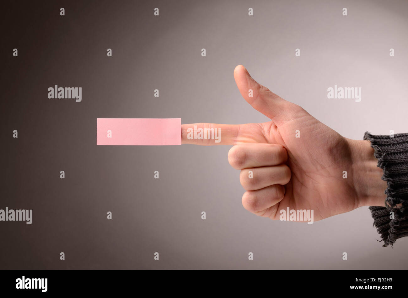 Male hand making a pistol with a sticky note on the index finger Stock ...