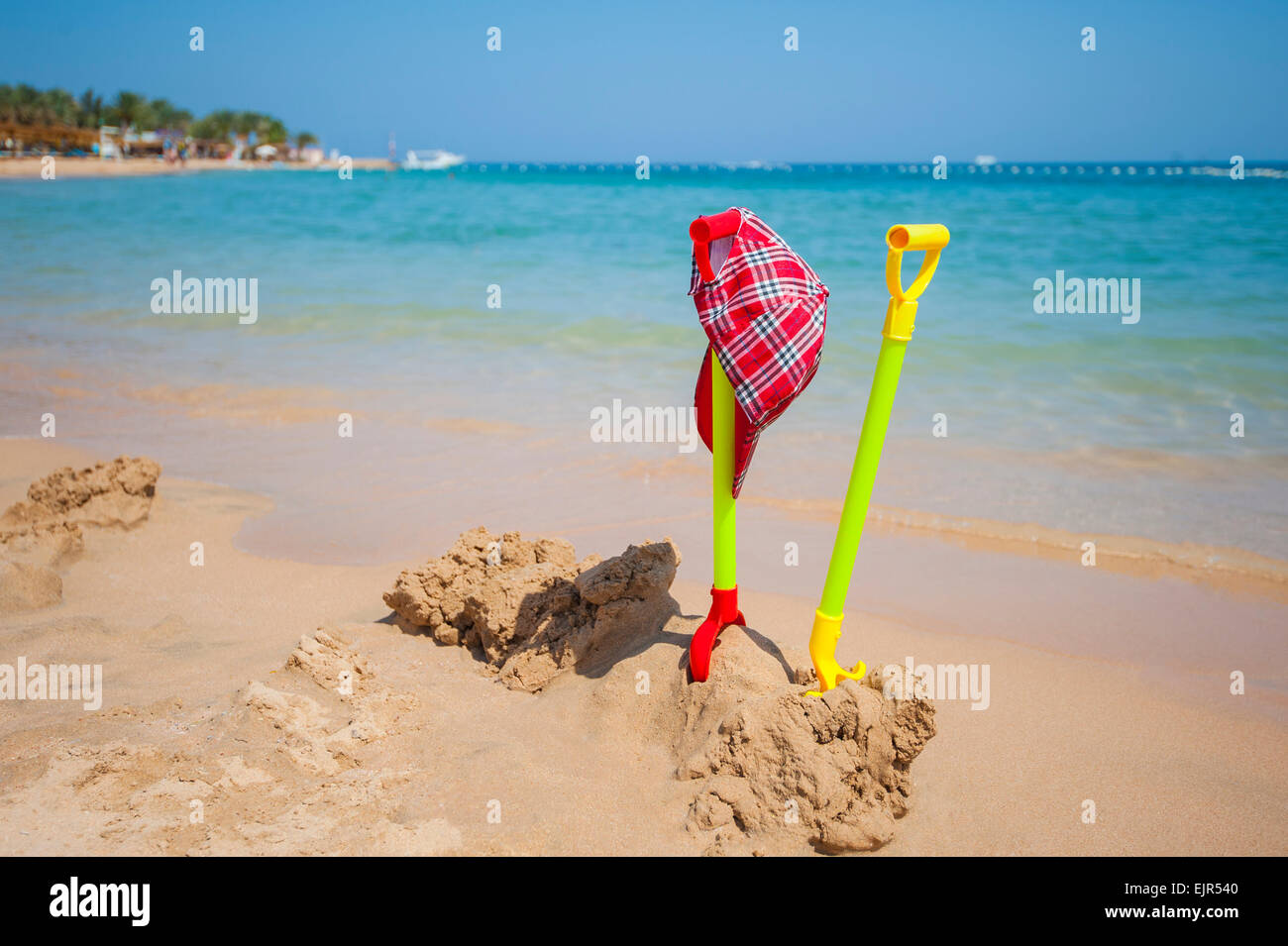 Two childrens plastic spade toys on a tropical beach resort in the ...