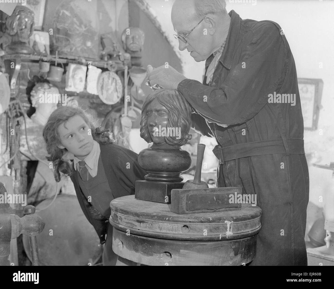 Sculptor William Snell seen here at work in his studio being watch by ...