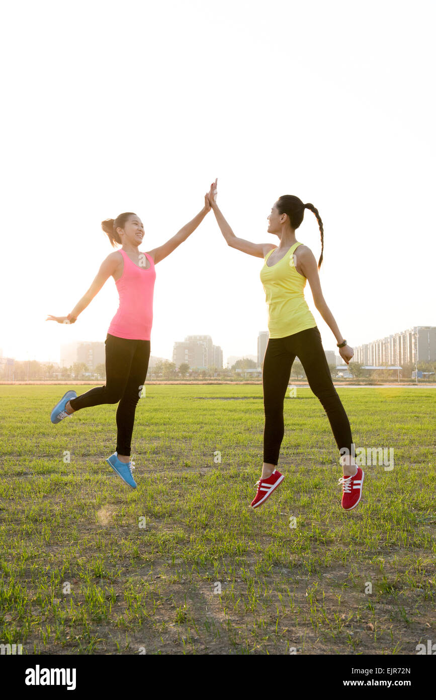 Girlfriends having high-five at playground Stock Photo - Alamy