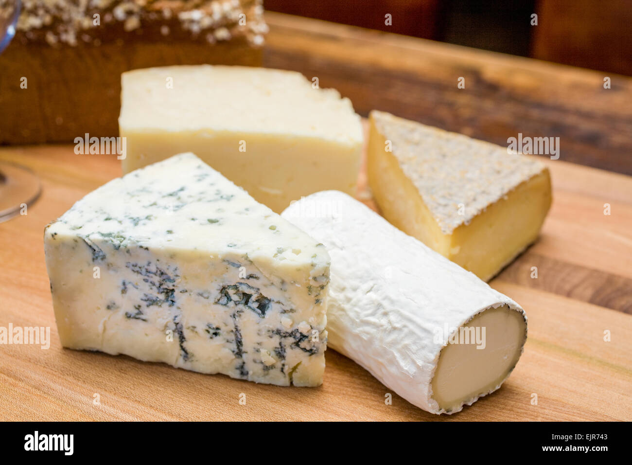 Assorted cheese segments on a chopping board Stock Photo - Alamy
