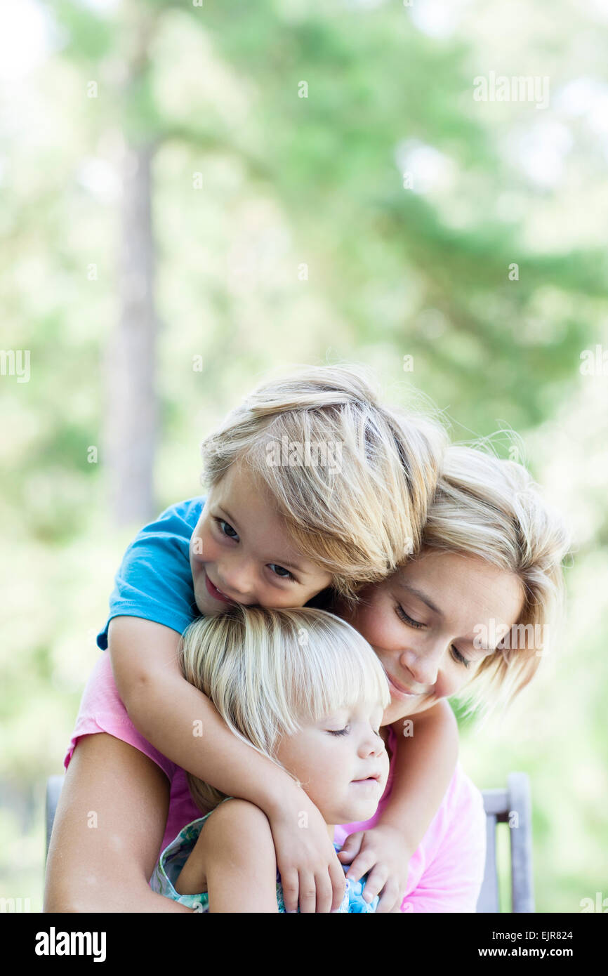 Caucasian mother hugging children outdoors Stock Photo - Alamy