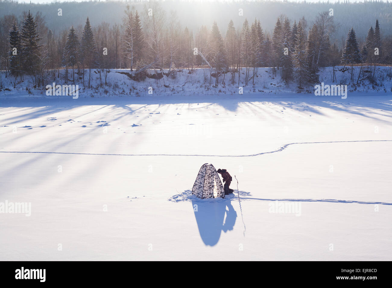 Mari man setting up tent in snowy field Stock Photo - Alamy