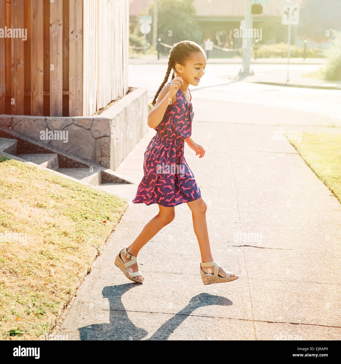 Mixed race girl walking on neighborhood sidewalk Stock Photo - Alamy