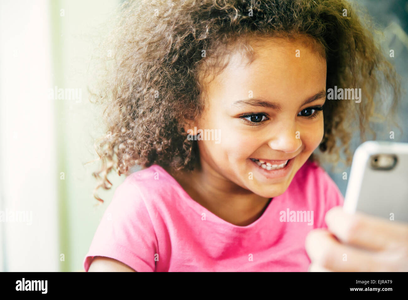 Cheerful girl watching mobile phone hi-res stock photography and images ...