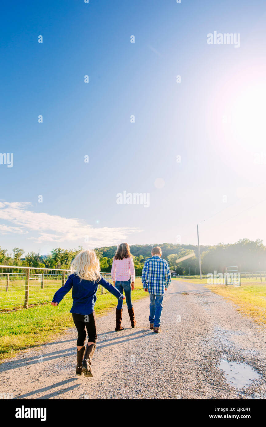 Caucasian children walking on dirt road on ranch Stock Photo - Alamy