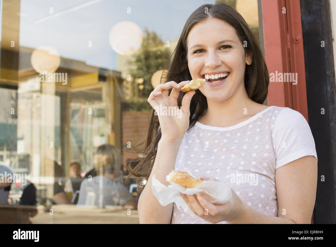 Caucasian woman eating outside cafe Stock Photo - Alamy