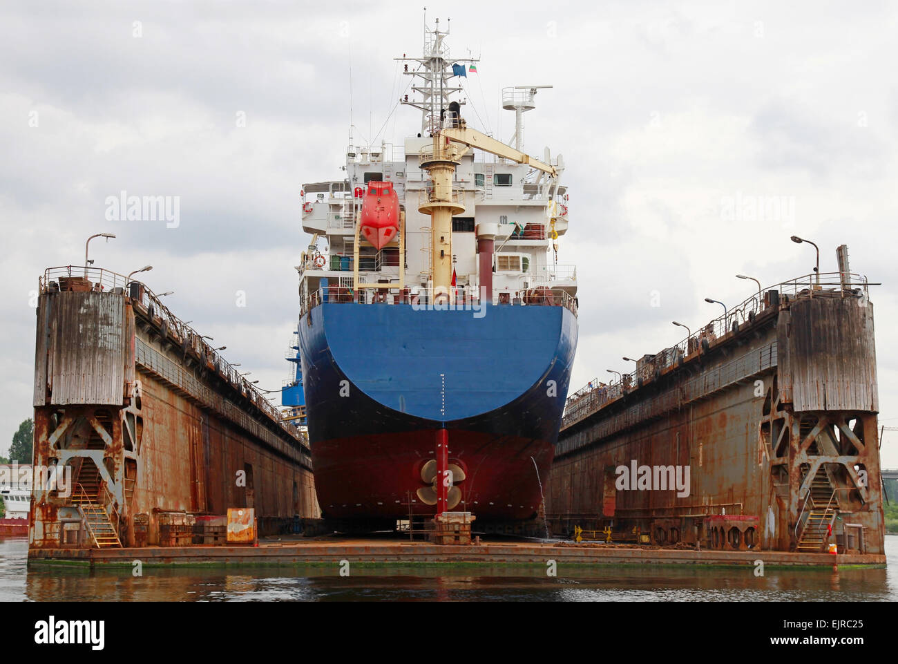 Floating dry dock with blue industrial tanker ship under repair inside ...