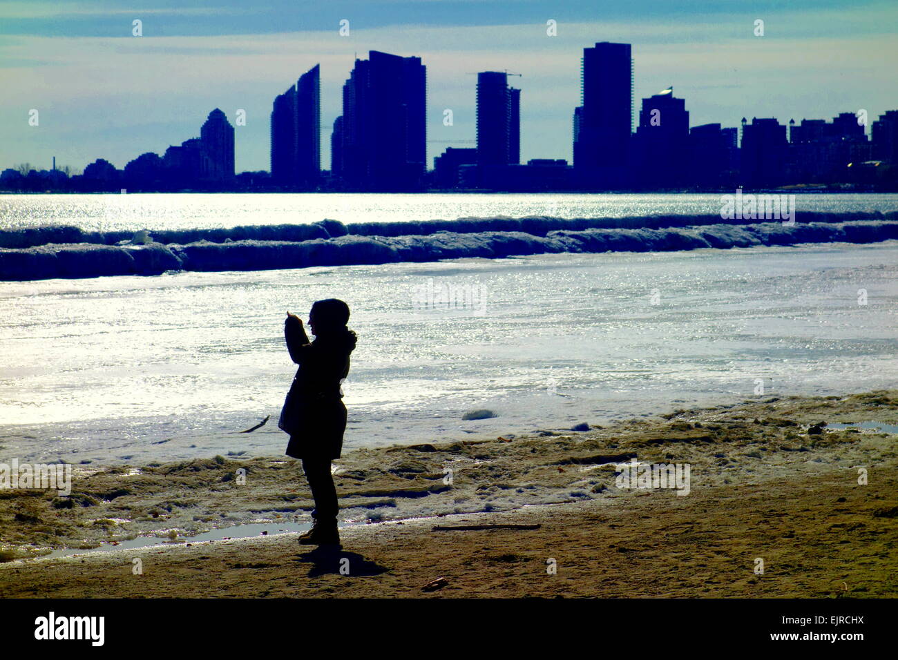 Woman taking photographs of the frozen Lake Ontario in Toronto Stock ...