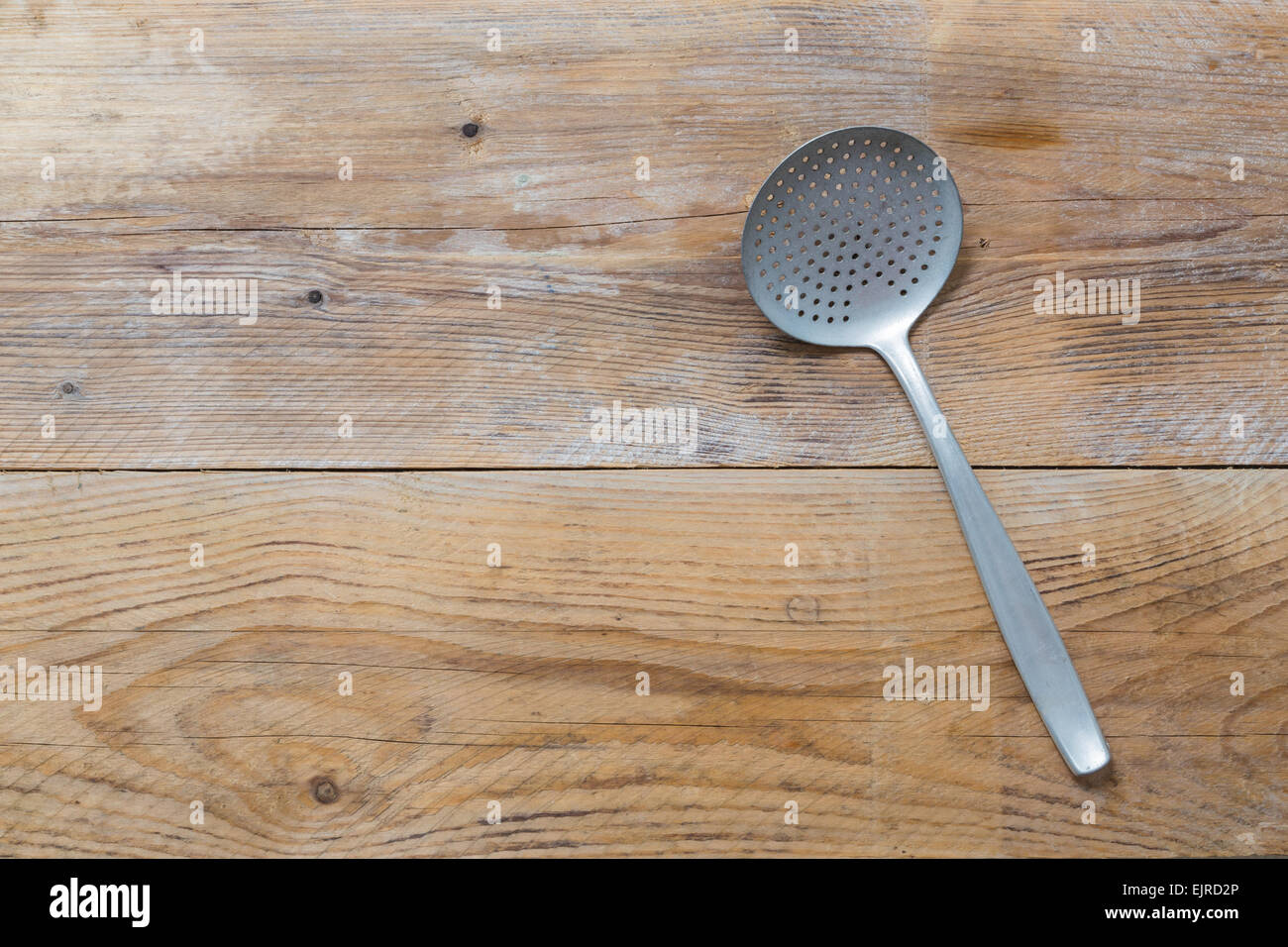 Slotted spoon on rustic wood background in bird's eye view Stock Photo ...