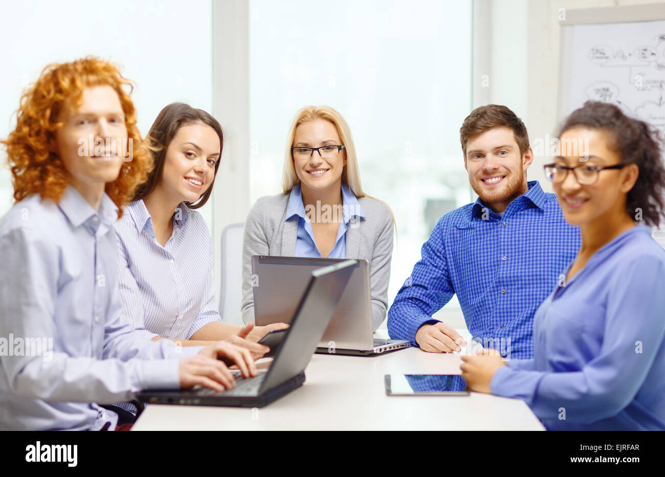 smiling team with laptop and table pc computers Stock Photo - Alamy