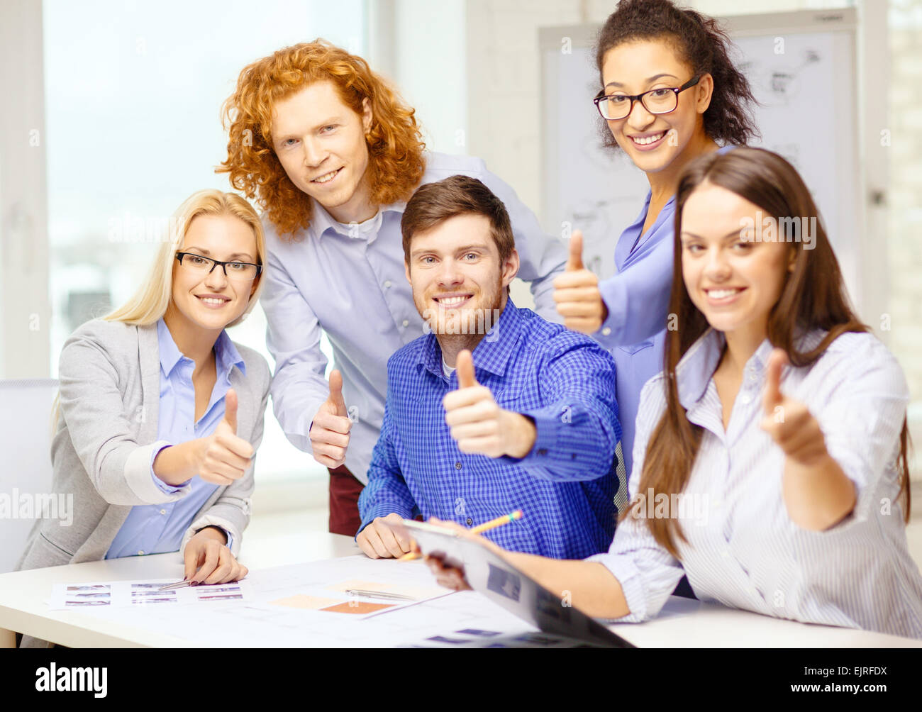 creative team with papers showing thumbs up Stock Photo - Alamy
