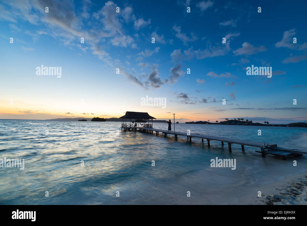 Romantic sky, first lights on the horizon and wooden jetty in tourist ...