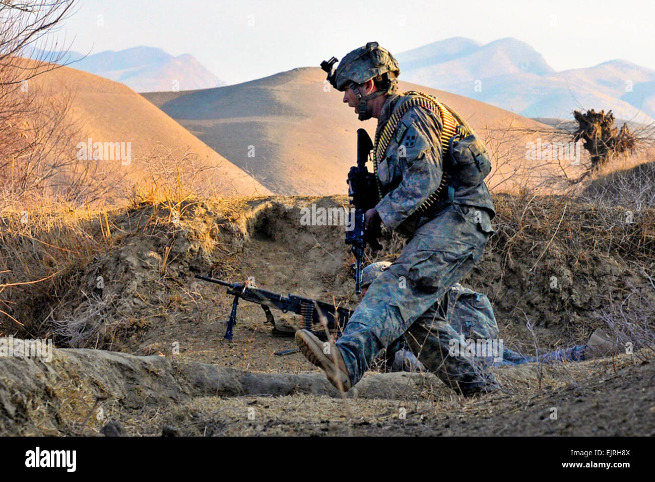 U.S. Army Soldiers take cover as they receive fire on a riverbed near ...