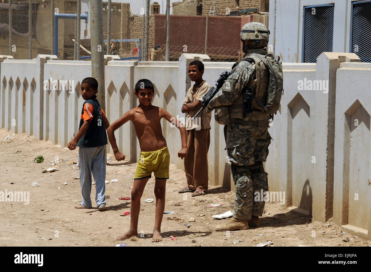 A young Iraqi boy strikes a muscle pose while standing next to a ...