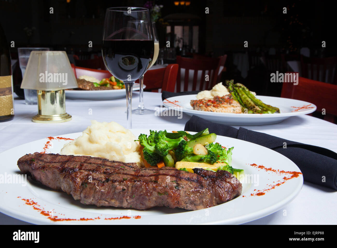 A white plate holds a delicious grilled New York Strip Steak with a ...