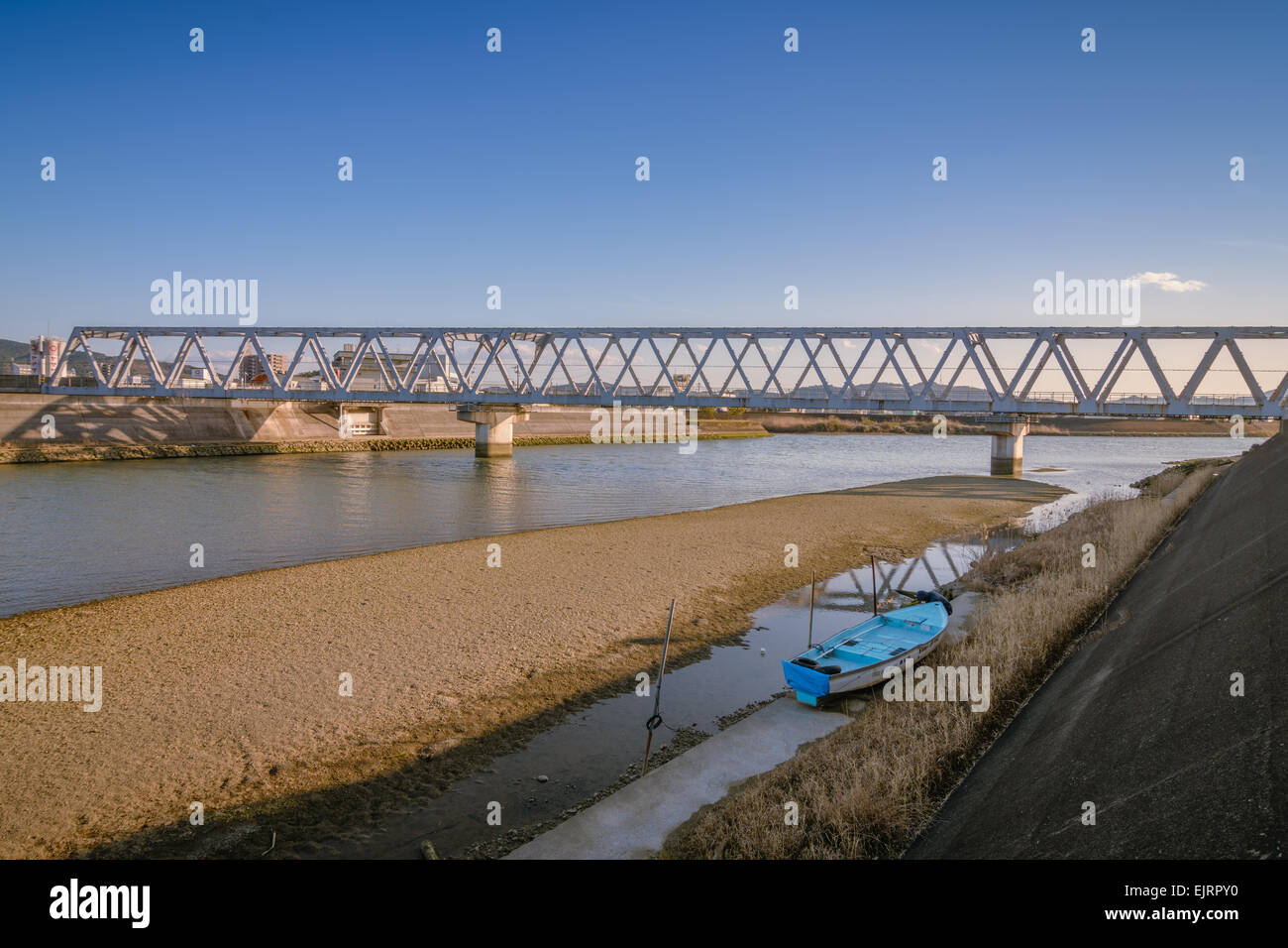A bridge over a small river with a small boat nearby Stock Photo - Alamy