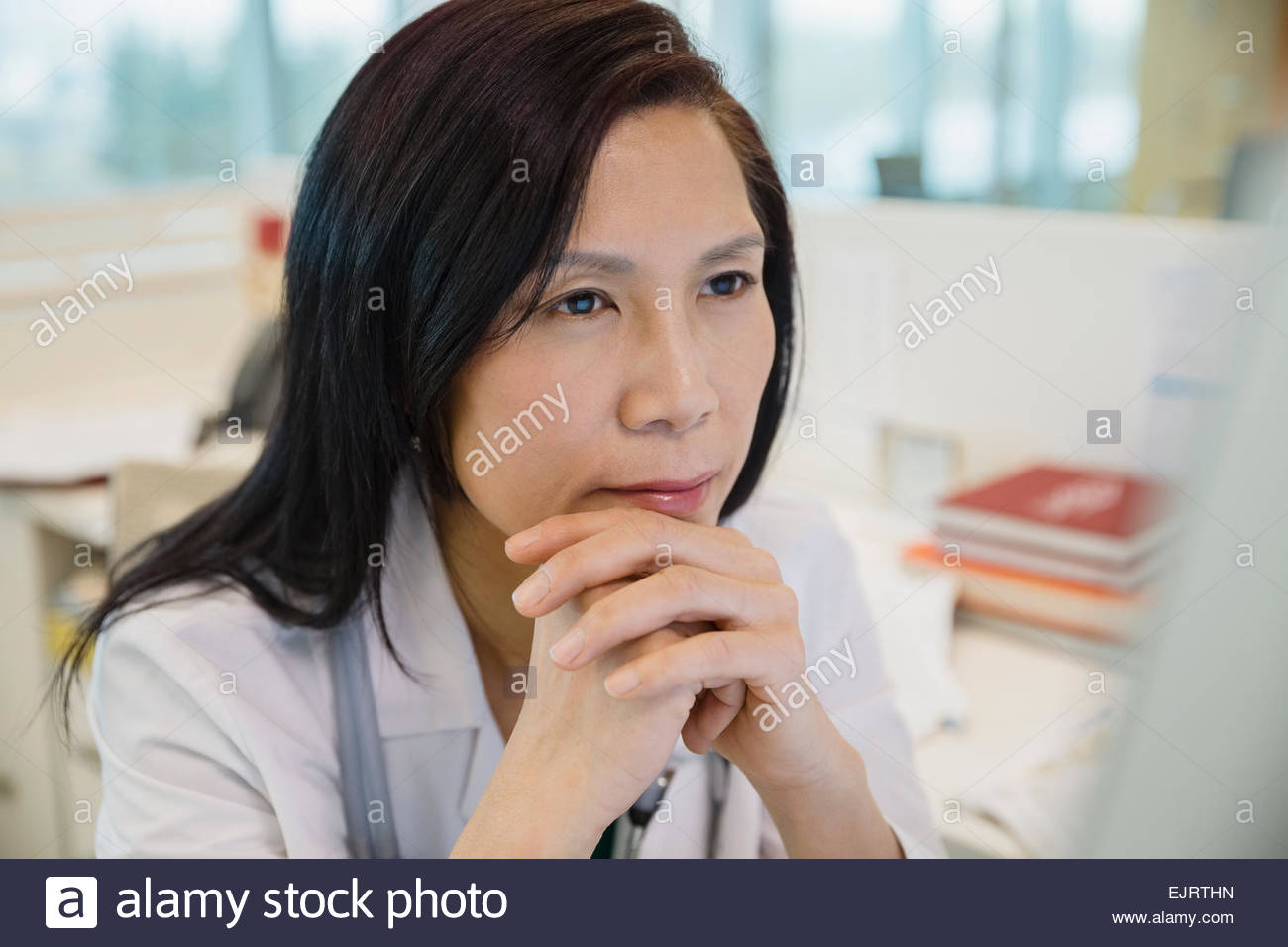 Serious doctor working at computer in clinic office Stock Photo - Alamy
