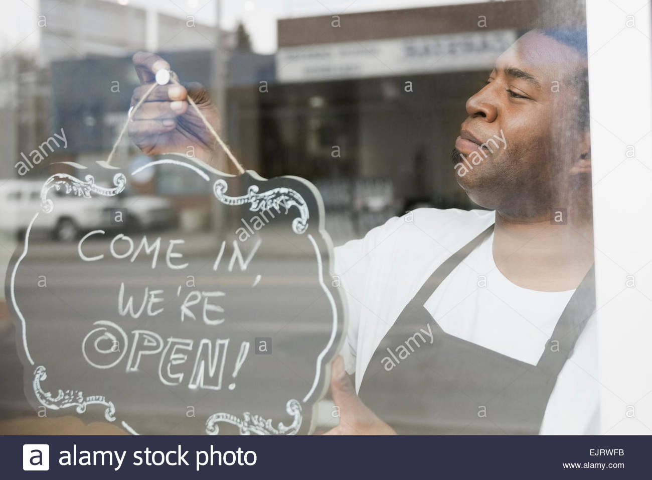 Proud business owner flipping open sign Stock Photo - Alamy
