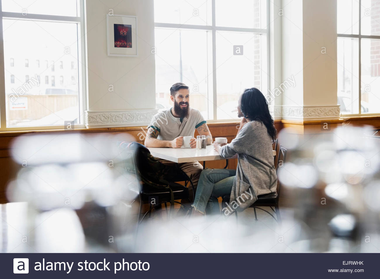 Couple drinking coffee at cafe table Stock Photo - Alamy