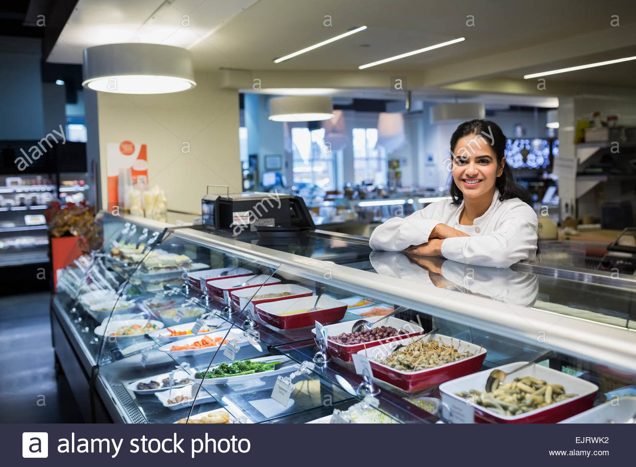 Portrait of confident worker behind deli case Stock Photo - Alamy