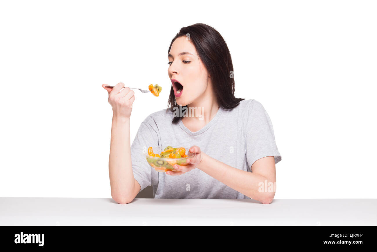 natural woman eating healthy food with orange and kiwi on white ...