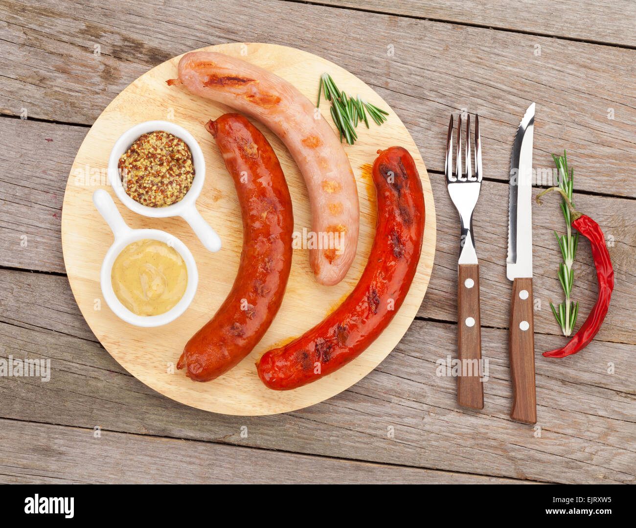 Various grilled sausages with condiments on cutting board Stock Photo ...