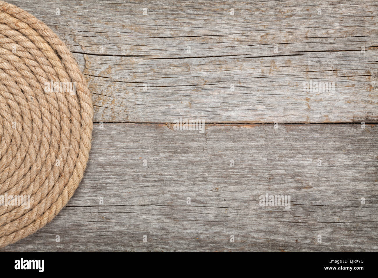 Roll of ship rope on wooden texture background Stock Photo - Alamy