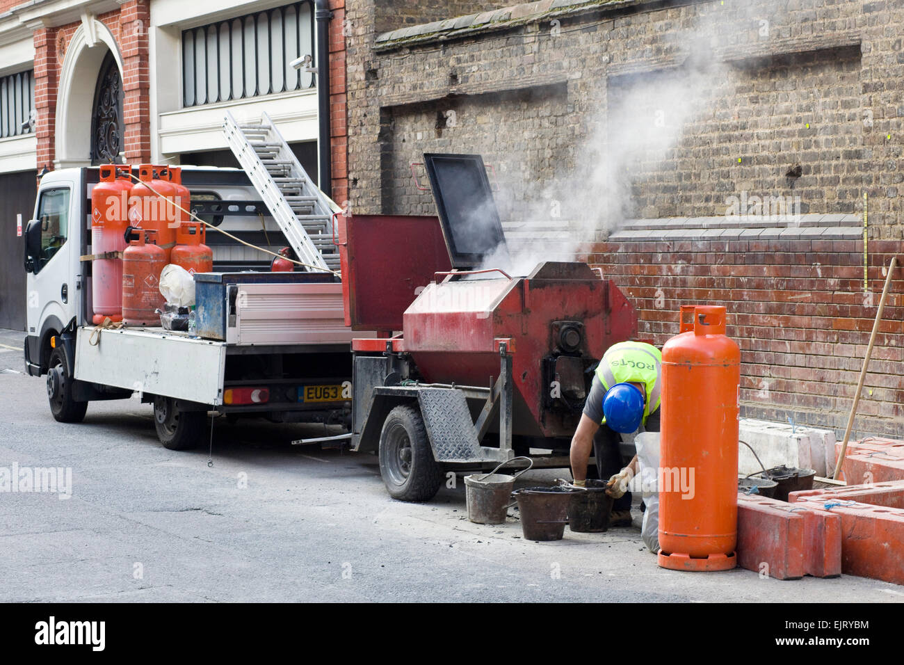 Workman melting tar in London Stock Photo - Alamy